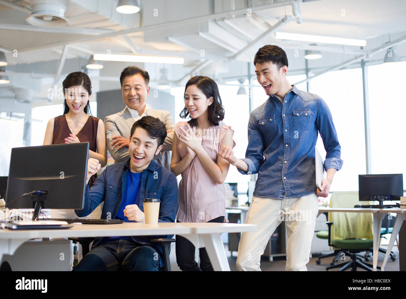 Chinese business people cheering in office Stock Photo - Alamy