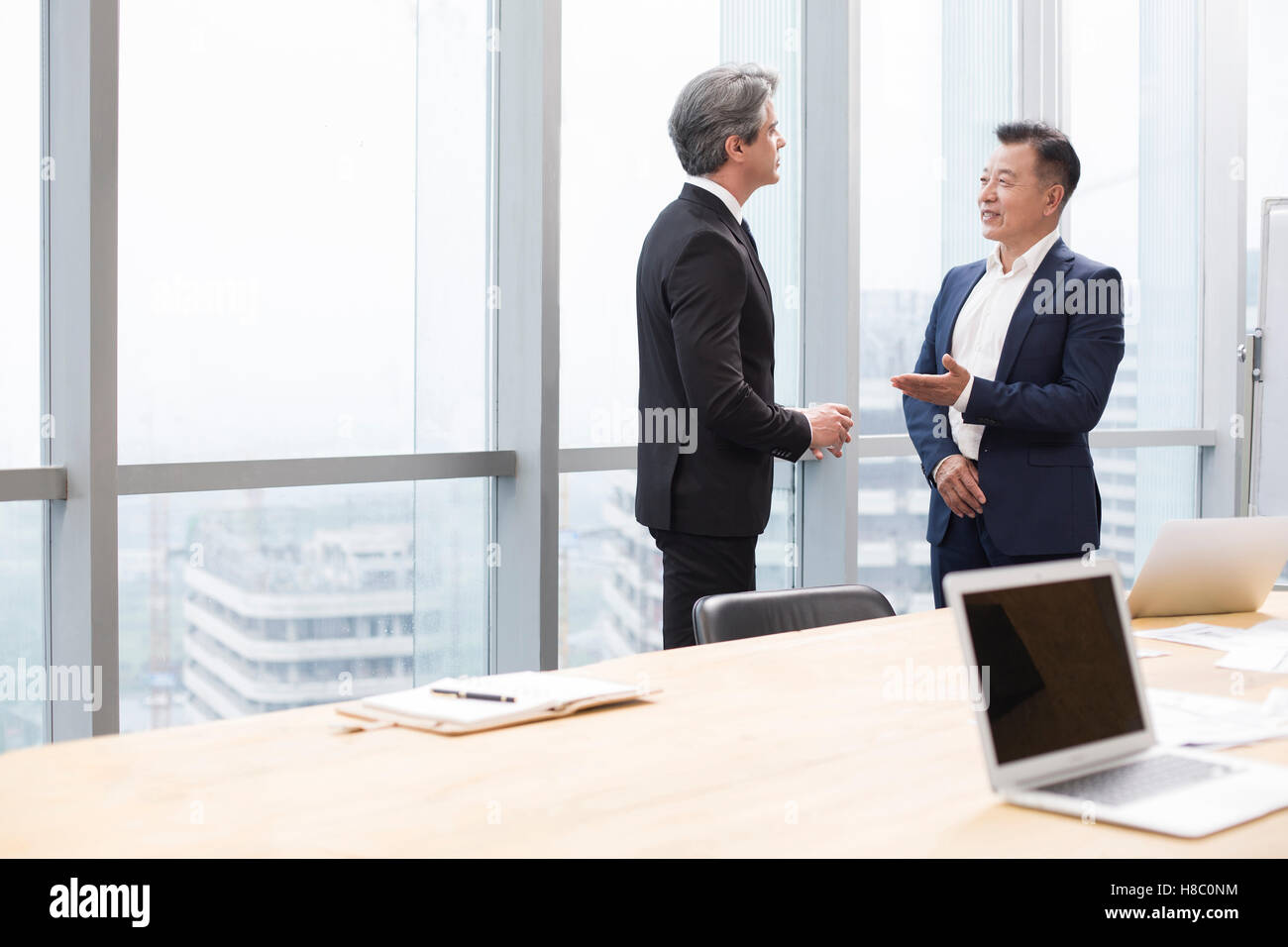 Chinese businessmen talking in meeting room Stock Photo - Alamy