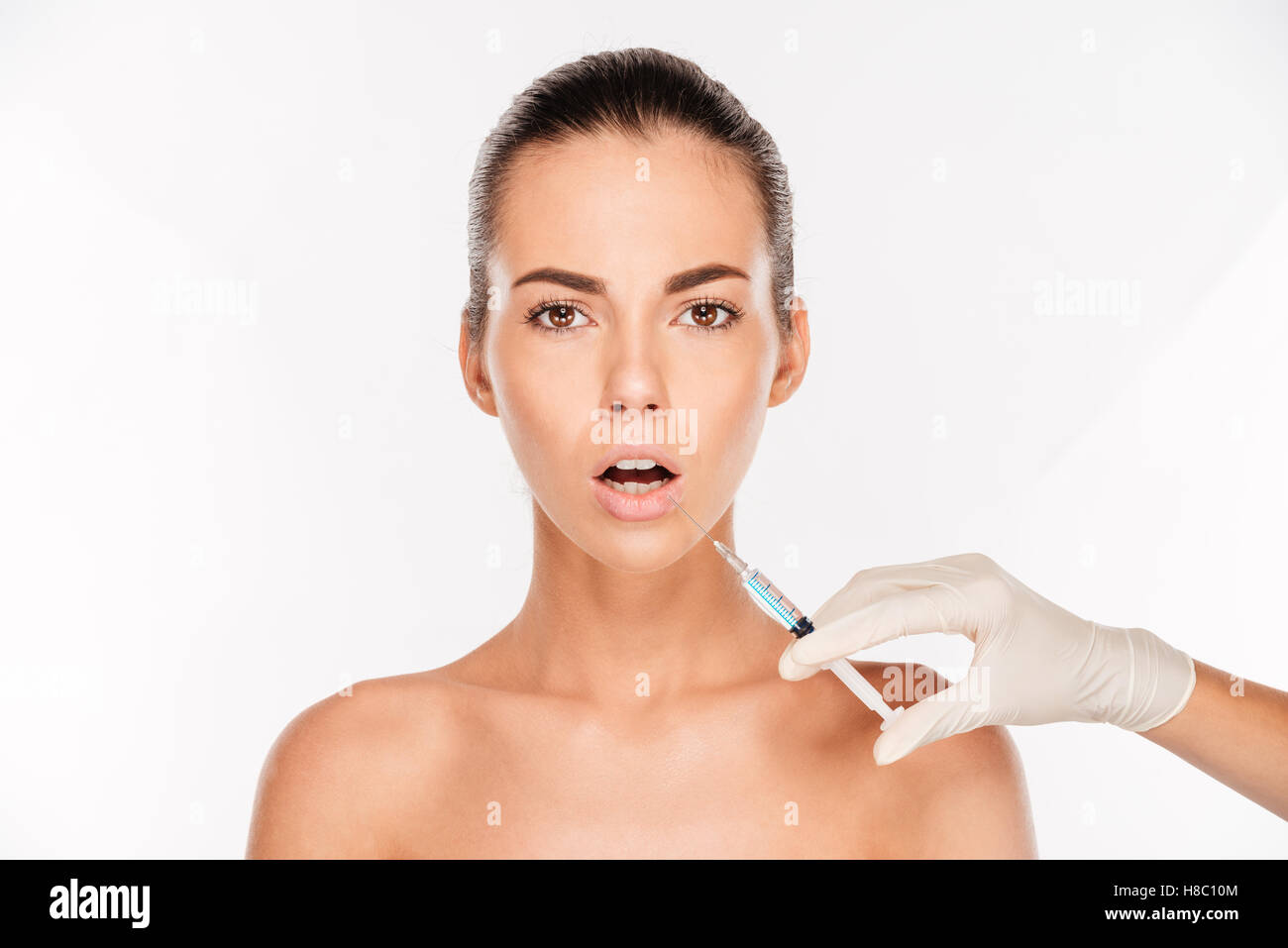 Scared young woman looking having beauty injection with syringe ...
