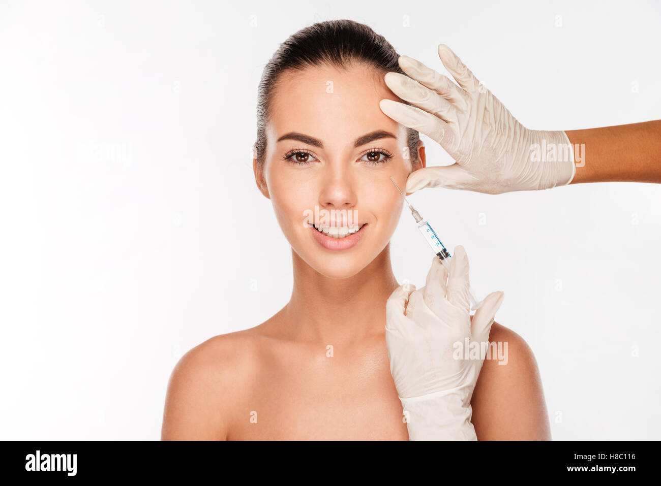 Beautiful young woman gets beauty injection in eye area from sergeant ...