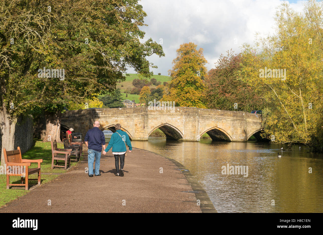 Older couple walking along the riverside path Bakewell, Derbyshire ...