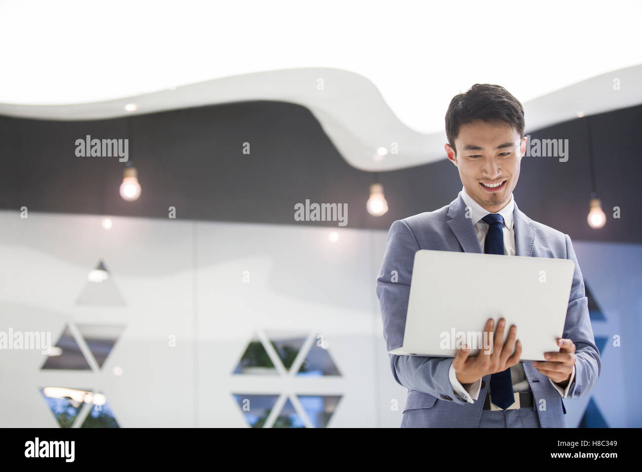 Young Chinese businessman working with laptop in office Stock Photo - Alamy