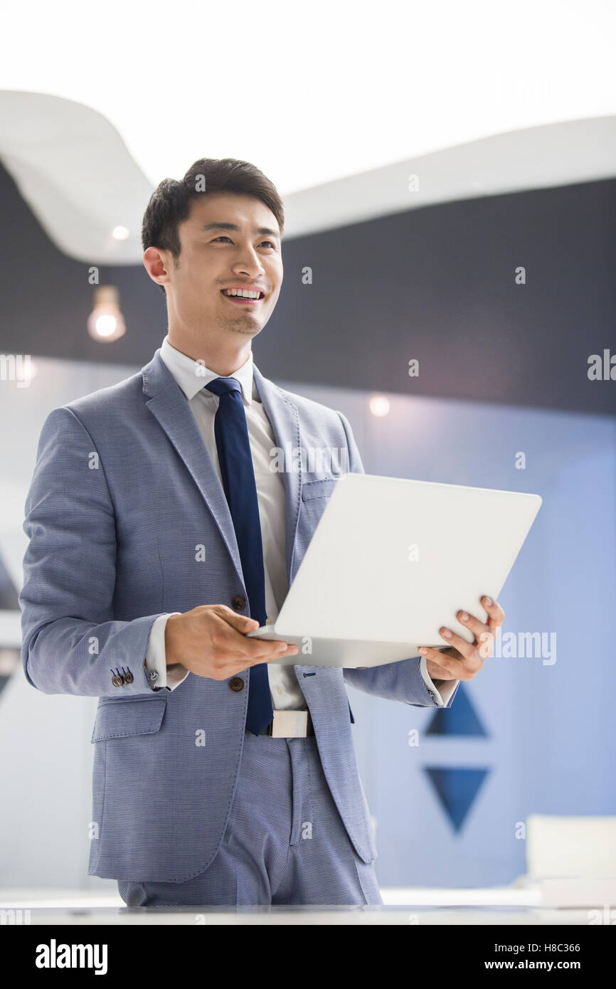 Young Chinese businessman working with laptop in office Stock Photo - Alamy