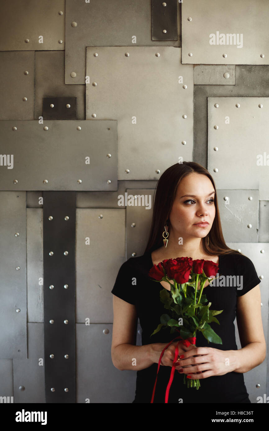 Beautiful brunette woman posing with red roses Stock Photo - Alamy