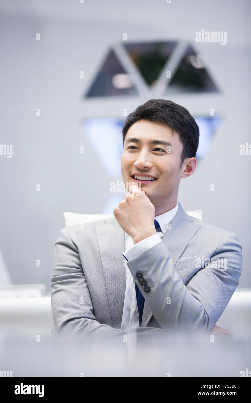 Young Chinese businessman thinking in office Stock Photo - Alamy