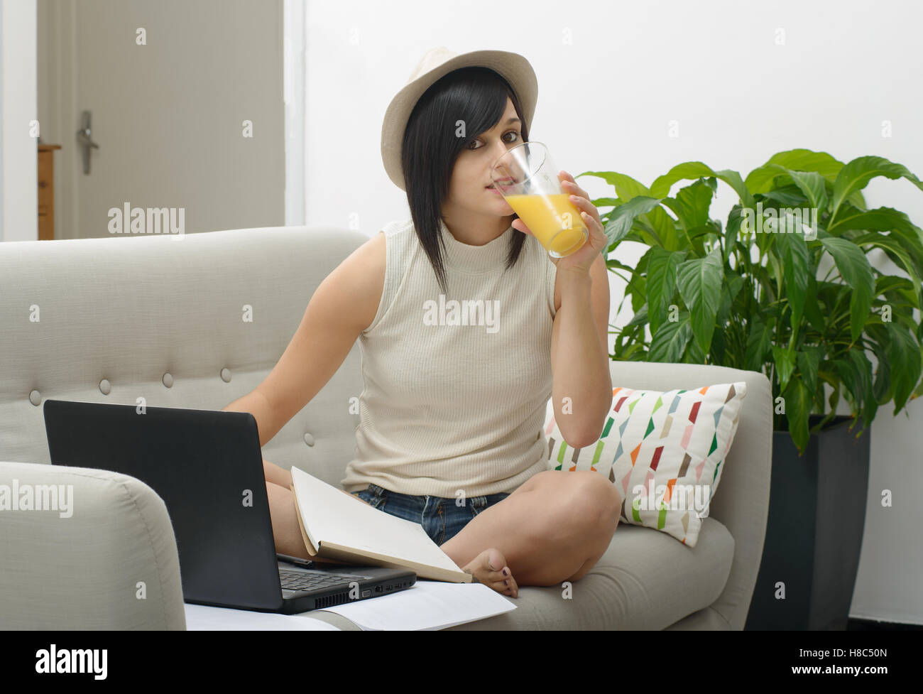 young student drinking orange juice in couch at home Stock Photo - Alamy