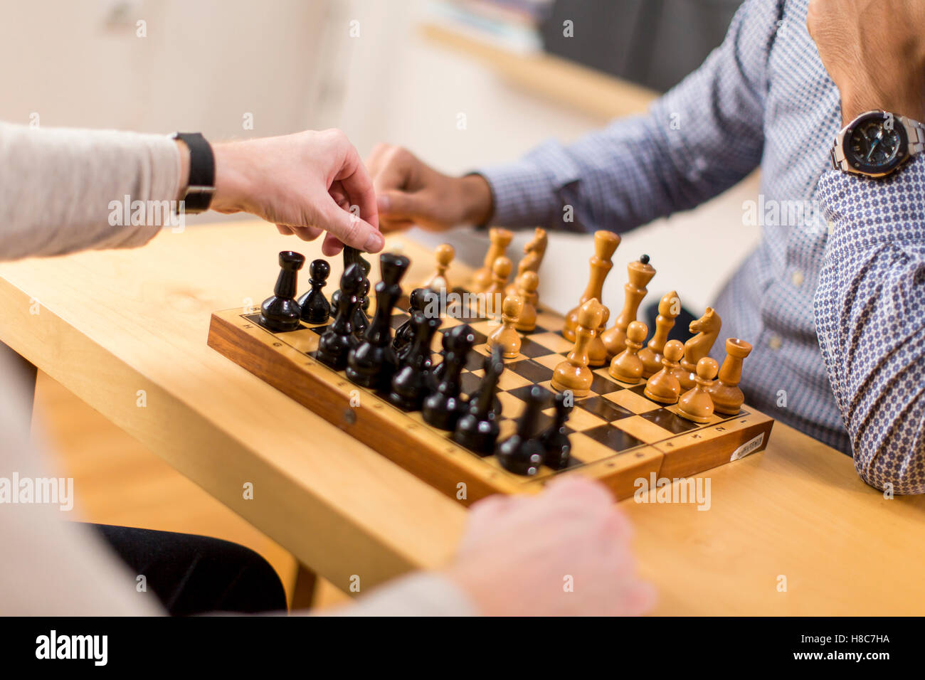 Two young men playing chess in room Stock Photo - Alamy