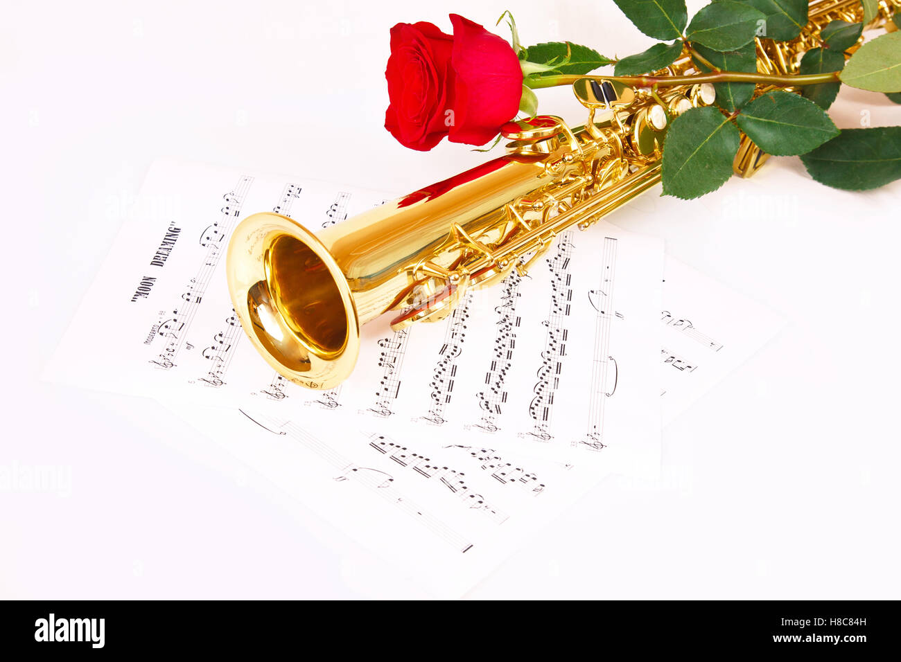 Red rose, saxophone and music sheet on a white background Stock Photo ...