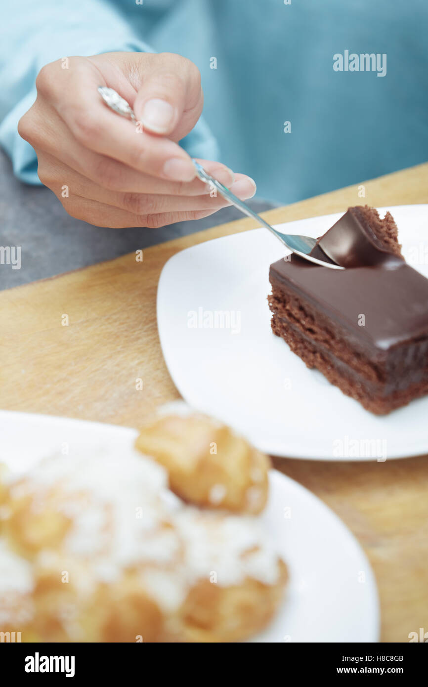 Hand of woman eating chocolate cake Stock Photo - Alamy