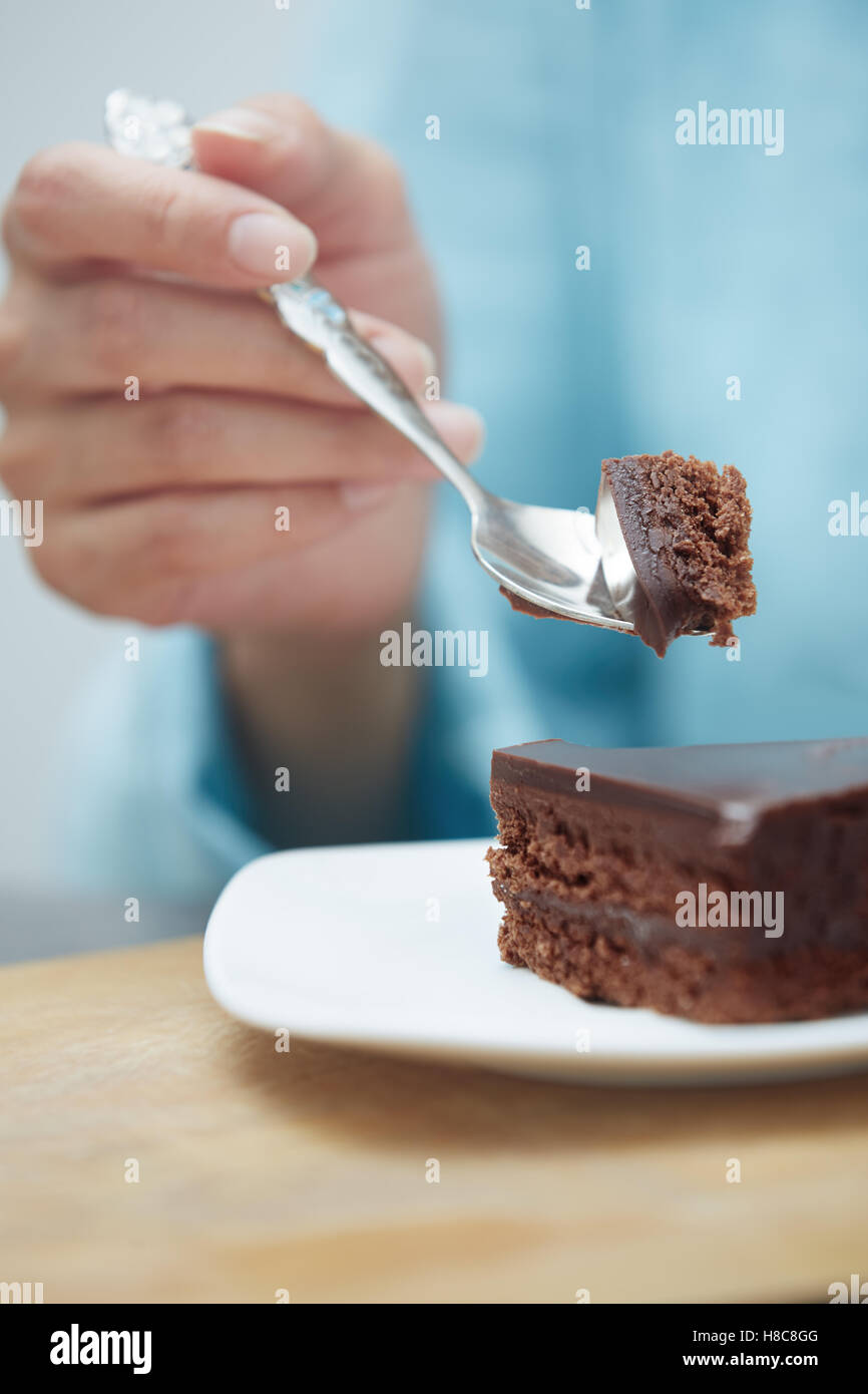 Hand of woman eating chocolate cake Stock Photo - Alamy