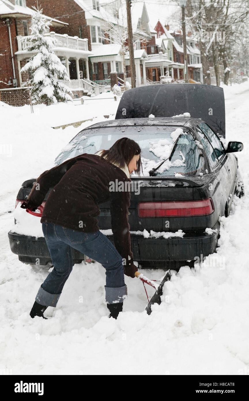 woman digging out her car after it got stuck Stock Photo - Alamy
