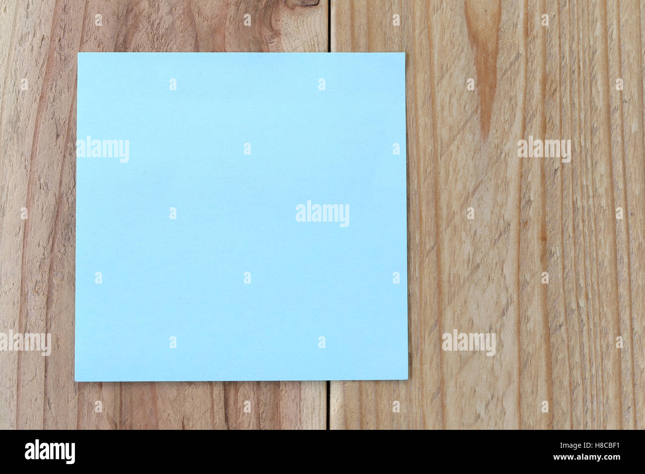 blue paper note on old brown wood background for design and input text ...