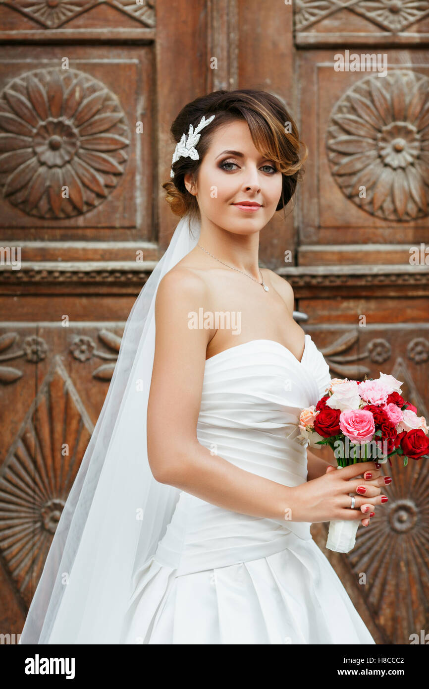 Bride standing near wooden door Stock Photo - Alamy