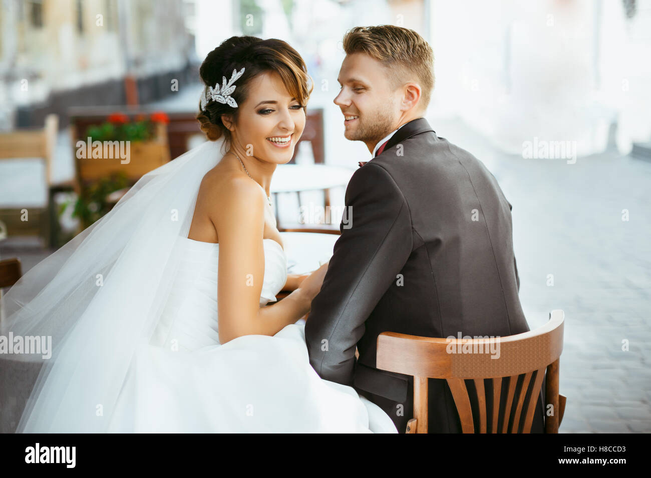 Bride and bridegroom sitting on chairs Stock Photo - Alamy