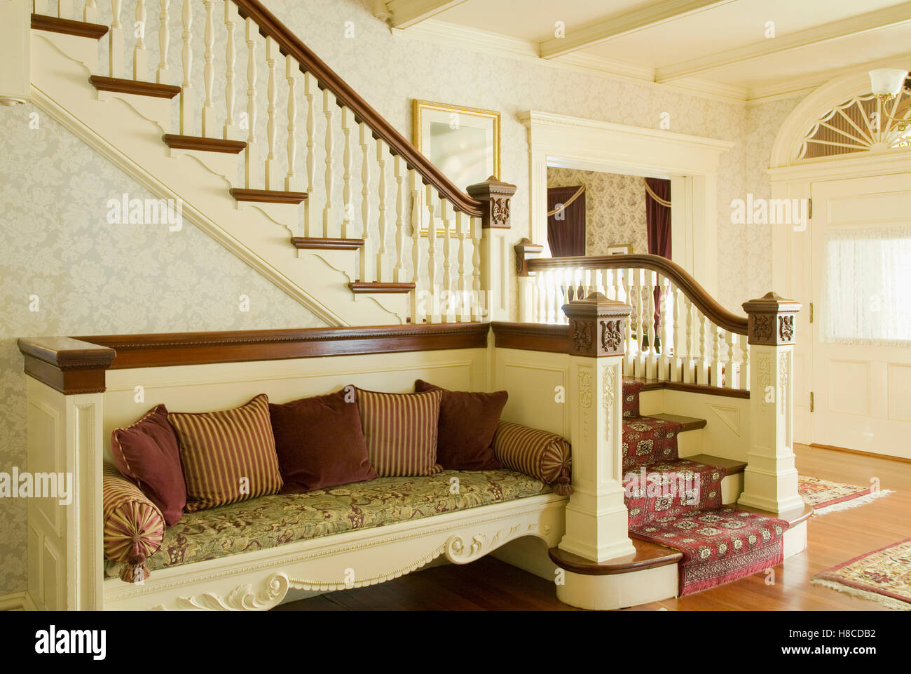 Built in seating with cushions in front of staircase in hallway Stock ...