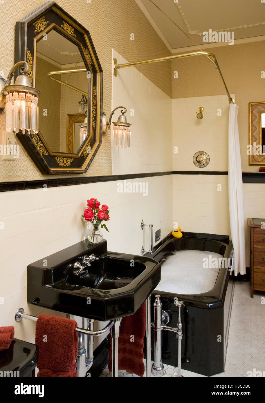 Octagonal mirror above black washbasin next to bathtub Stock Photo - Alamy