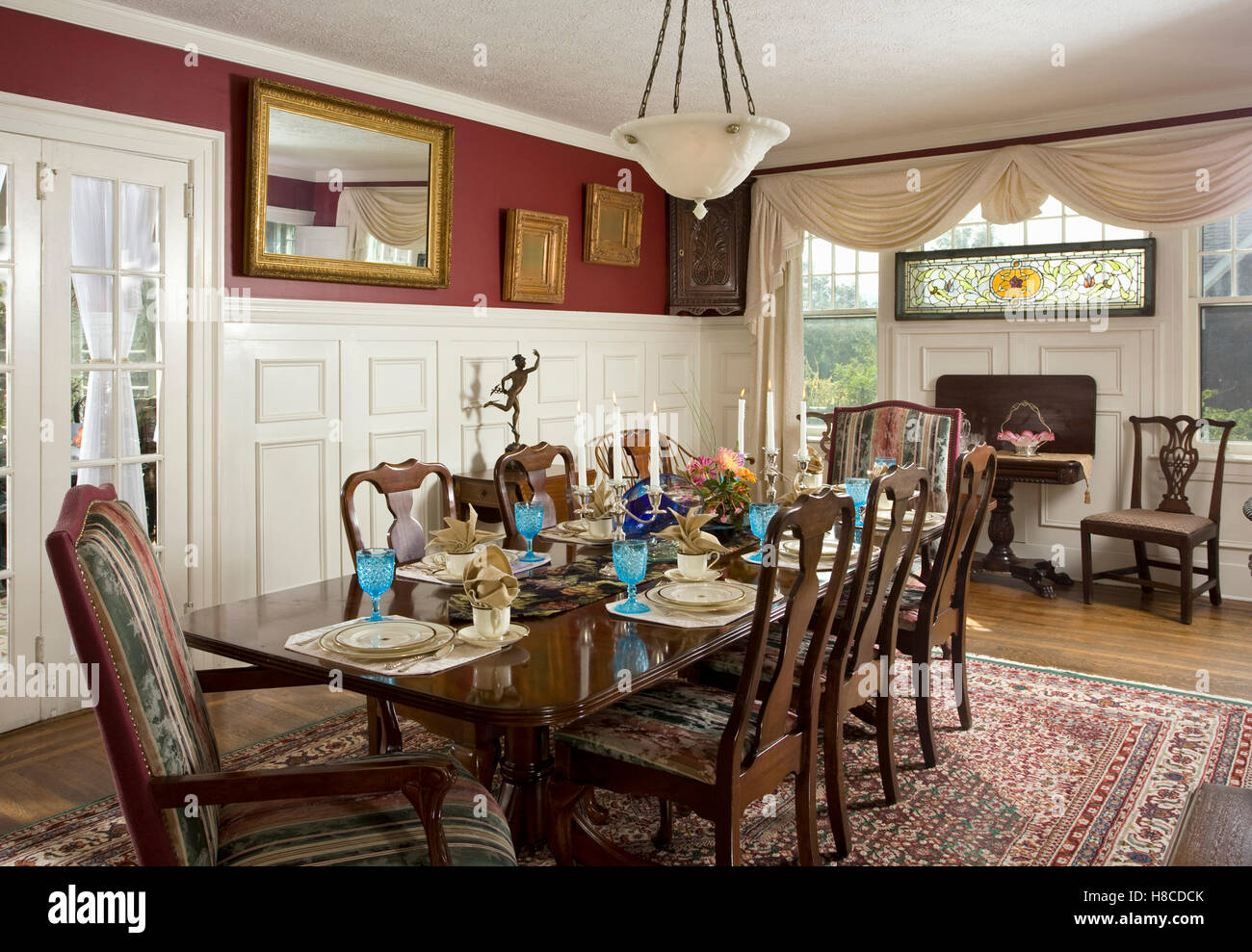 Table set for dinner in red dining room Stock Photo - Alamy