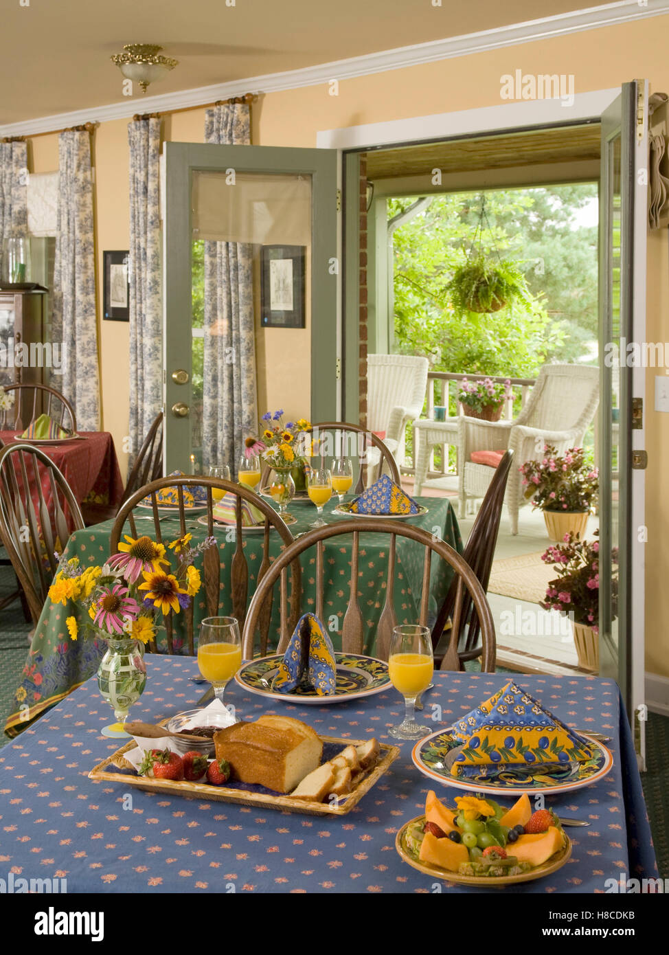 Several dining tables with breakfast place settings and open doors ...