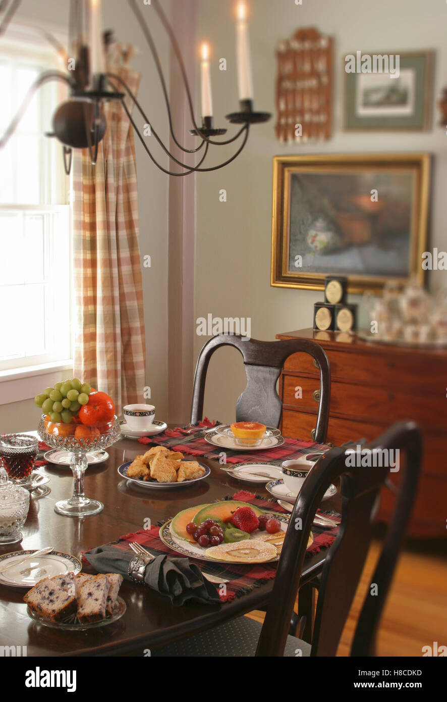 Chandelier with lit candles above table laid for candlelit breakfast ...