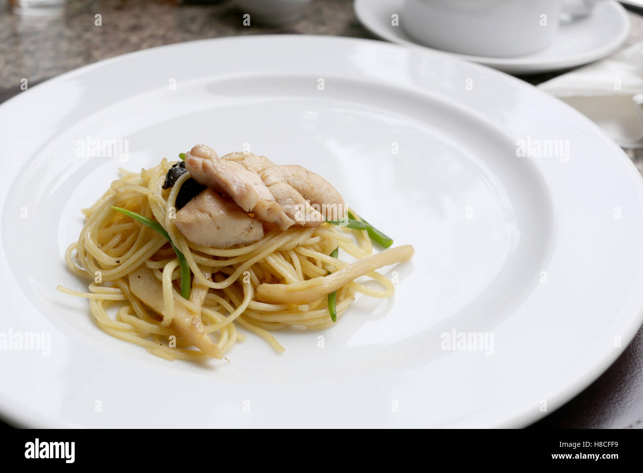 Puff yellow noodles with chicken meat on white dish in Breakfast ...