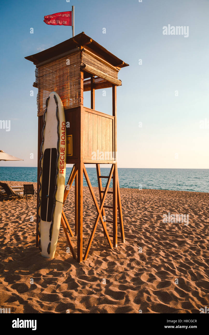 life guard station with red flag and canoe Stock Photo - Alamy