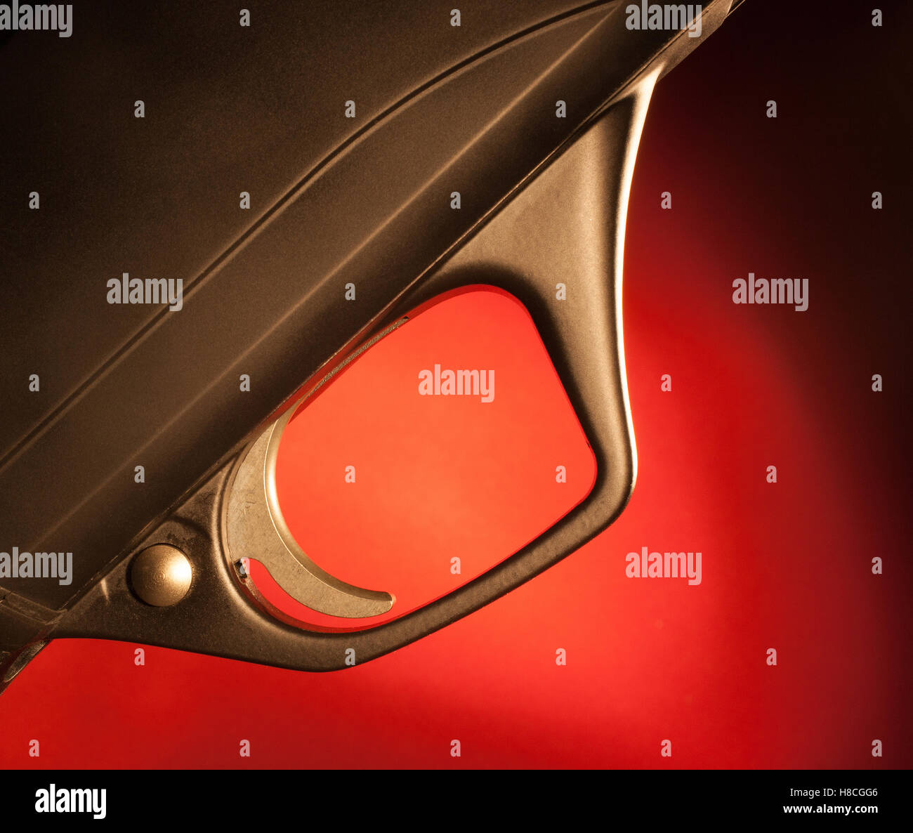 Firearm trigger that is metal with a red background Stock Photo - Alamy