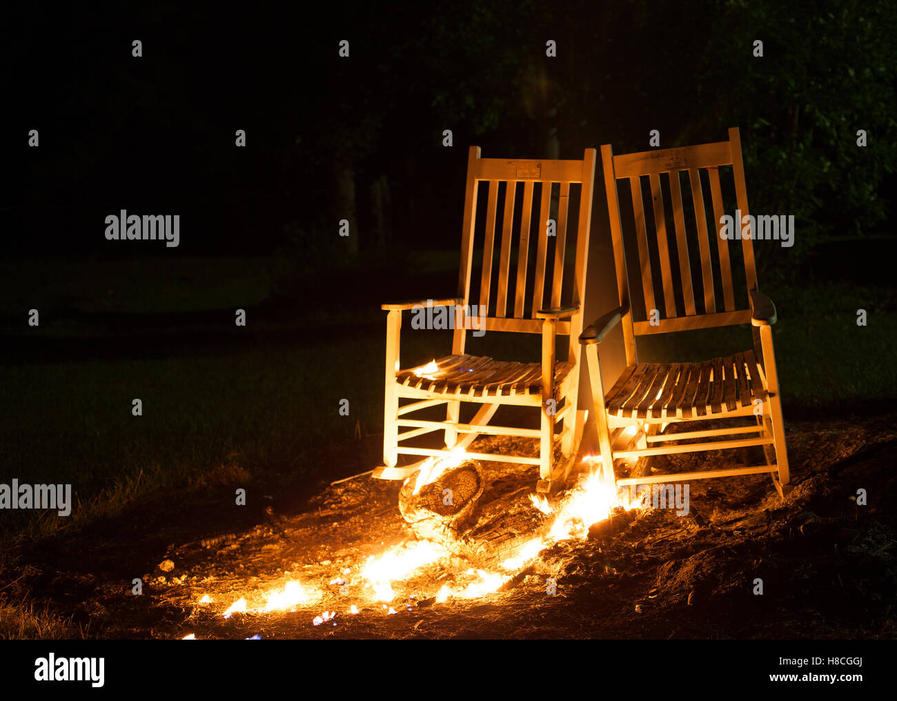 Rocking chairs on fire with the flames spreading out Stock Photo - Alamy