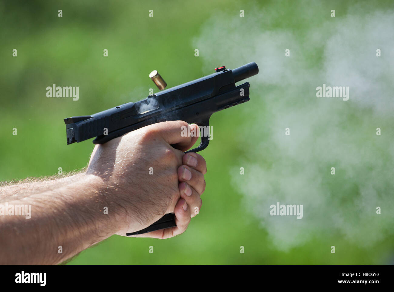 Smoking handgun that is ejecting an empty shell Stock Photo - Alamy