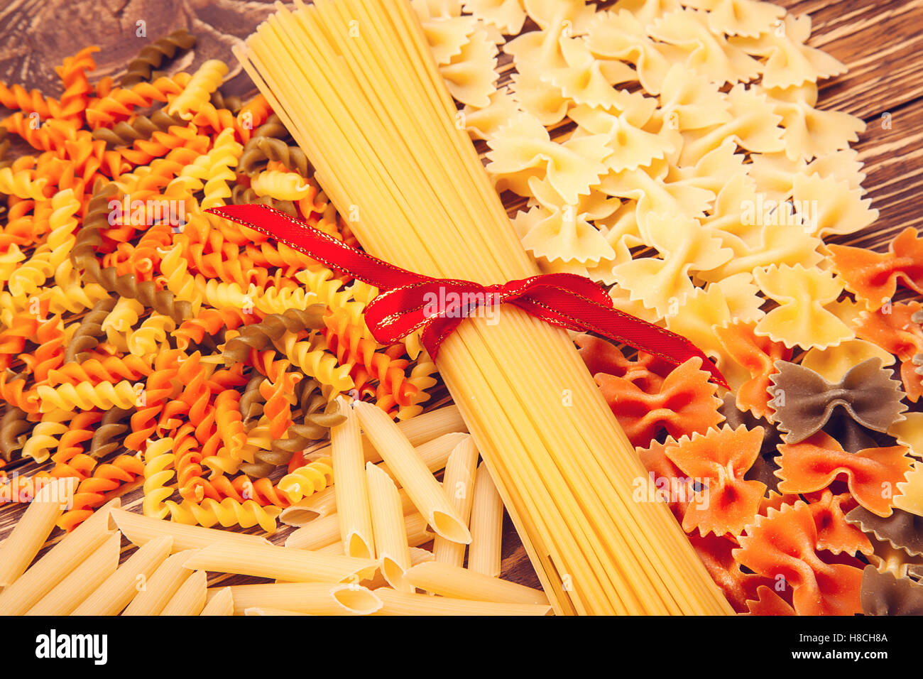 Spaghetti tied with a red ribbon, a number of different types of pasta ...