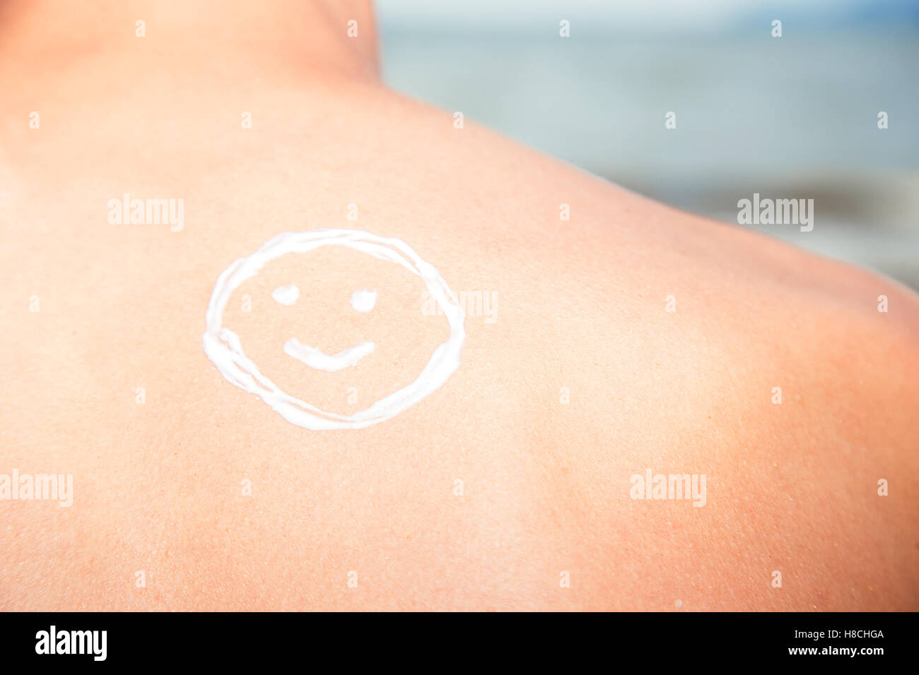 Lotion man with sunscreen smiley above sea background Stock Photo - Alamy