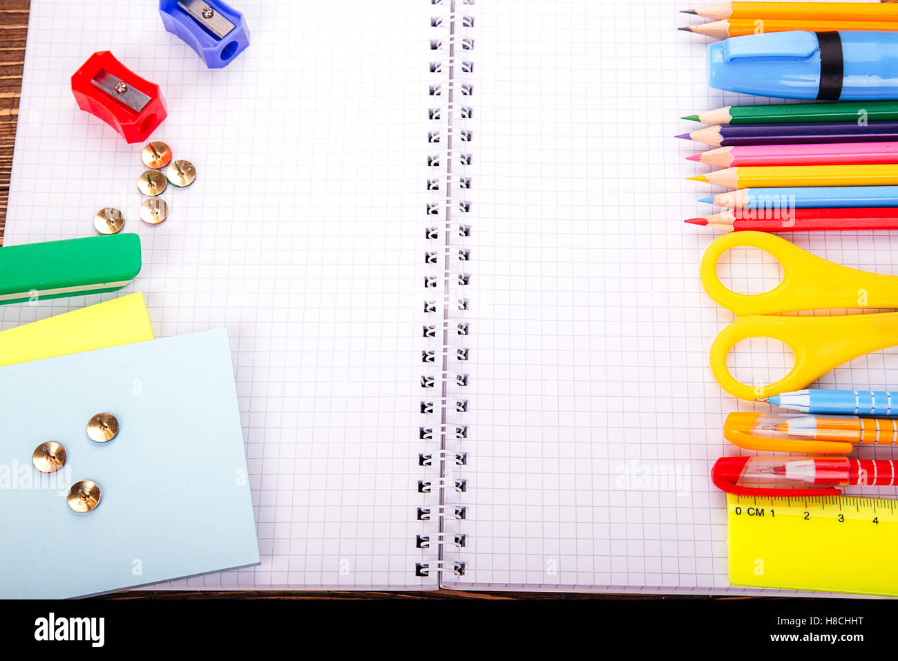 Opened blank notebook, frame of school supplies over a retro wooden ...