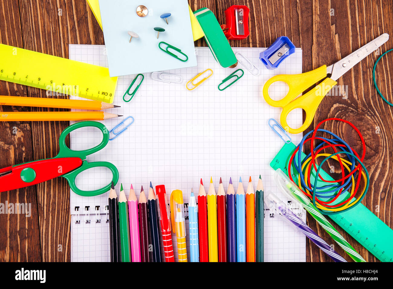 Opened blank notebook, frame of school supplies over a retro wooden ...
