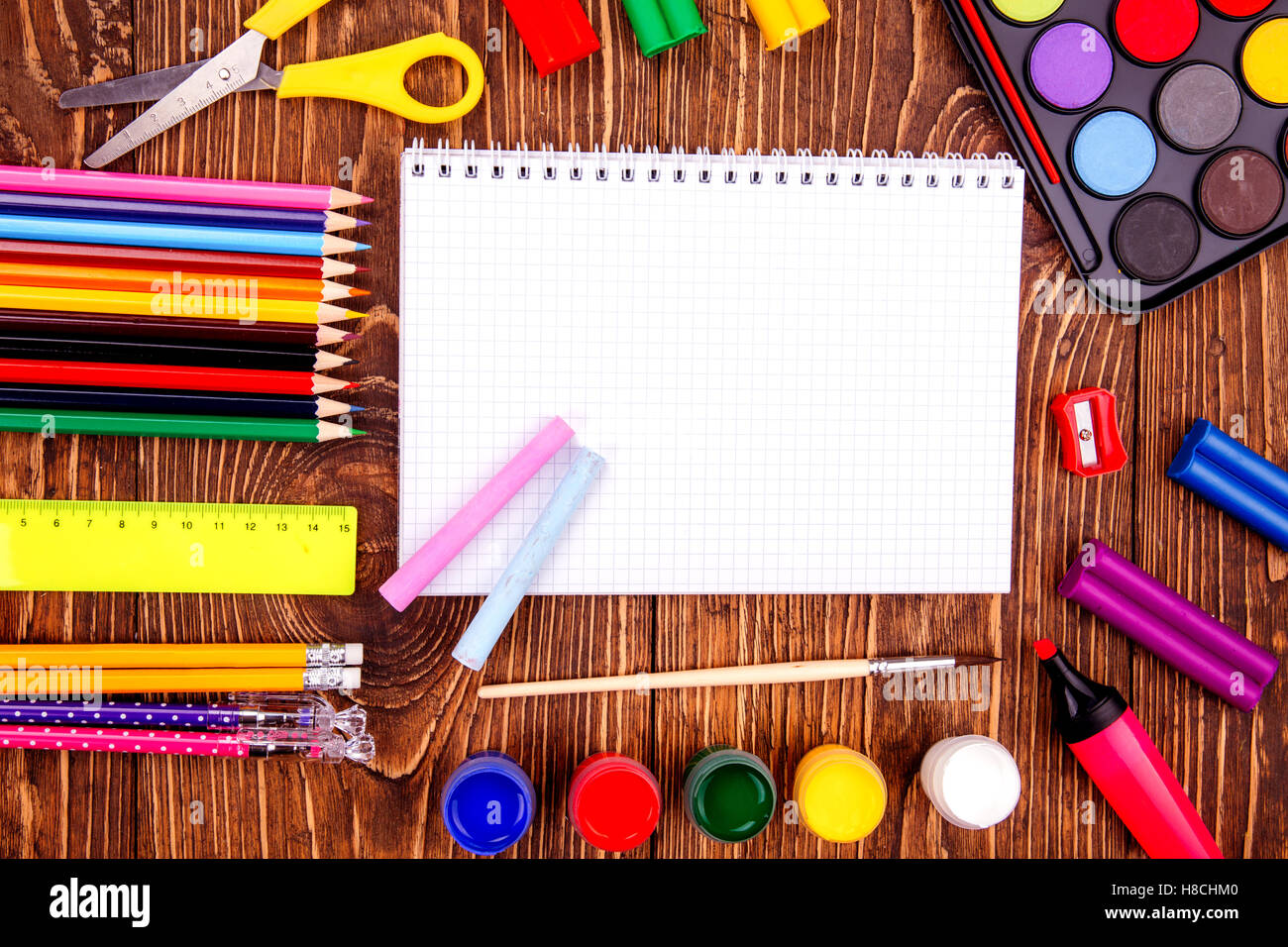 Opened blank notebook, frame of school supplies over a retro wooden ...