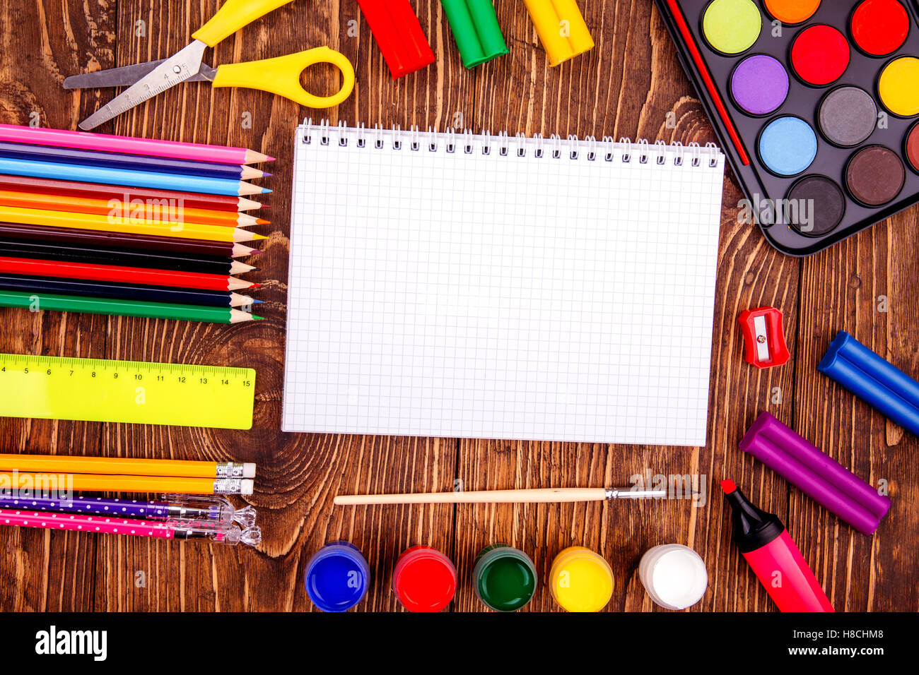 Opened blank notebook, frame of school supplies over a retro wooden ...