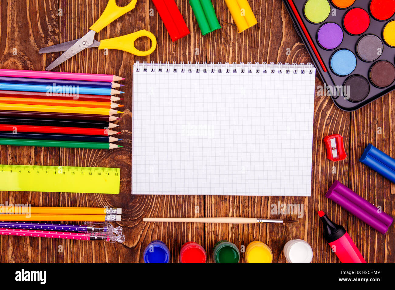Opened blank notebook, frame of school supplies over a retro wooden ...