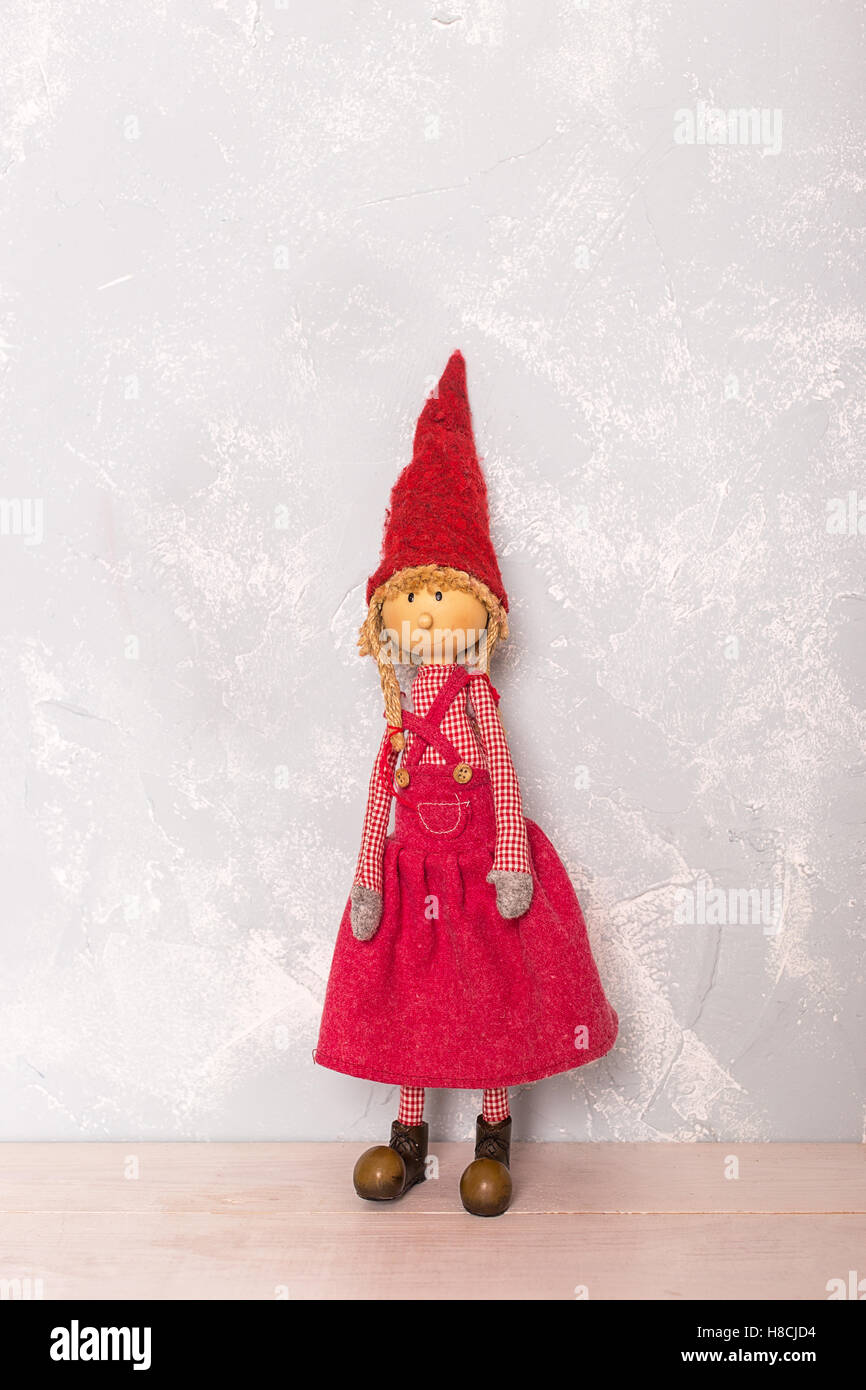 toy red doll girl on the wooden floor against the backdrop of a blue ...