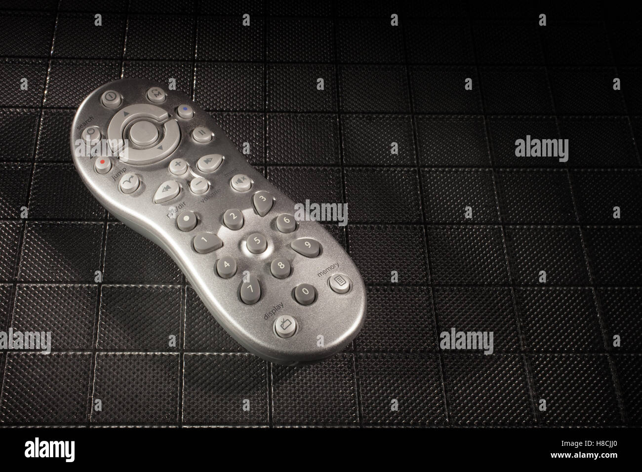 Silver looking remote control on a textured background Stock Photo - Alamy