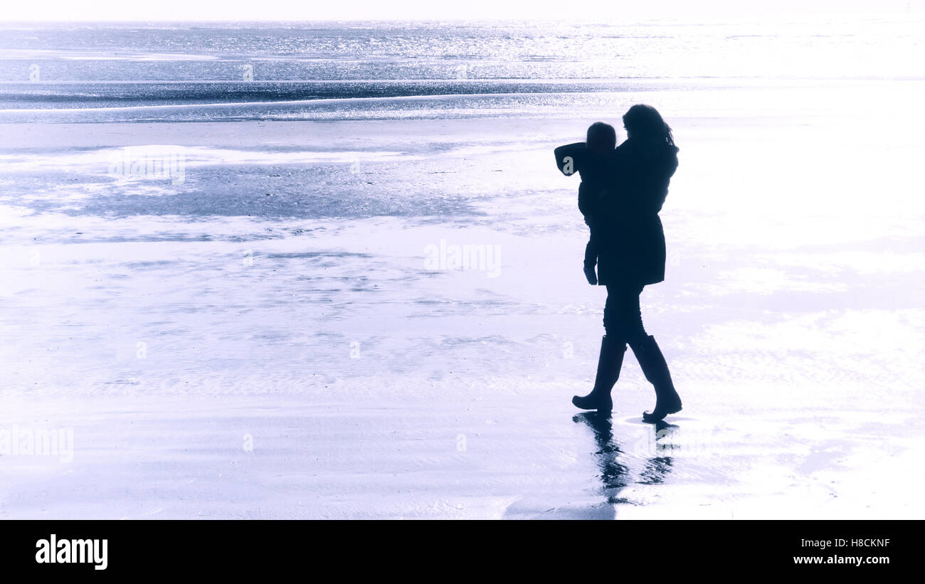 A mother walking alone with her child alone a empty seafront, lots of ...