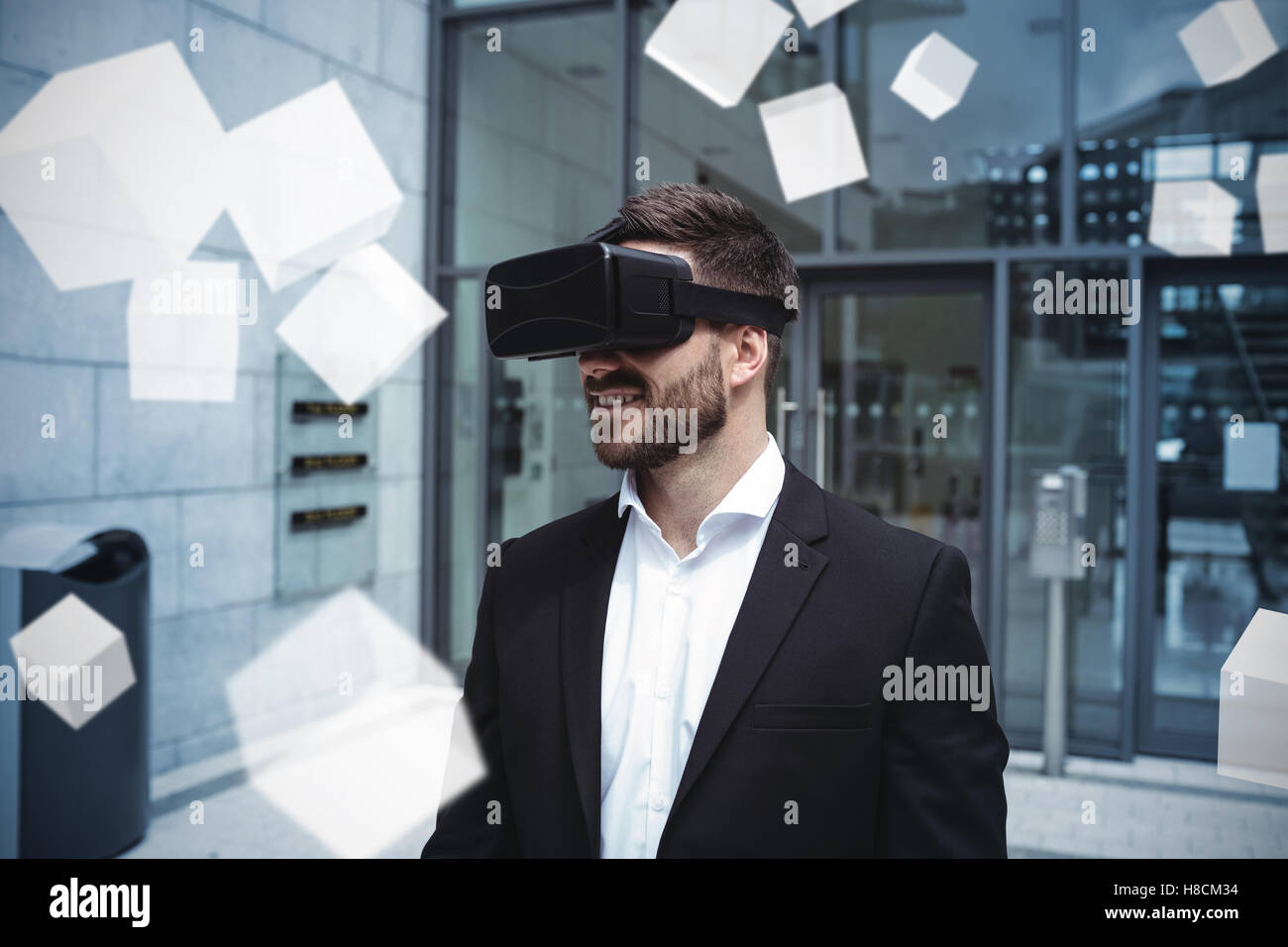 Digitally generated grey cubes floating against businessman using ...