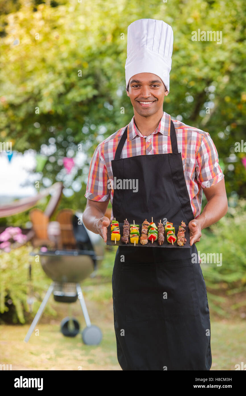 Handsome man preparing barbecue for friends, France Stock Photo - Alamy