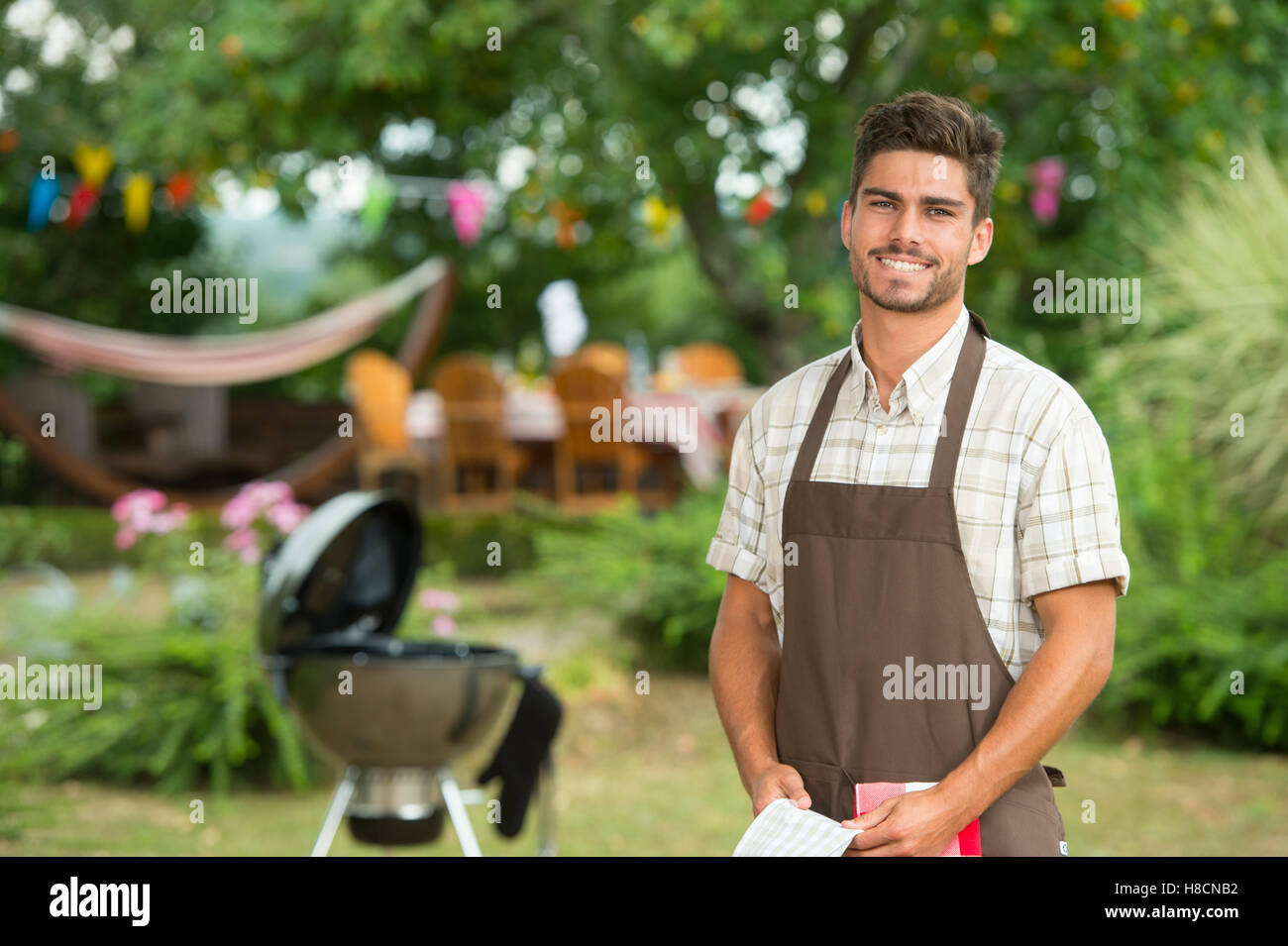 Handsome man preparing barbecue for friends, France Stock Photo - Alamy