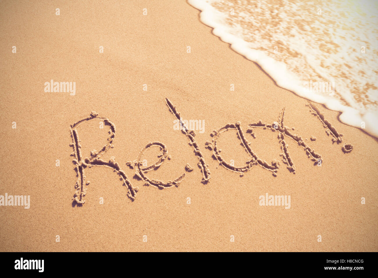 Relax written on sand Stock Photo - Alamy