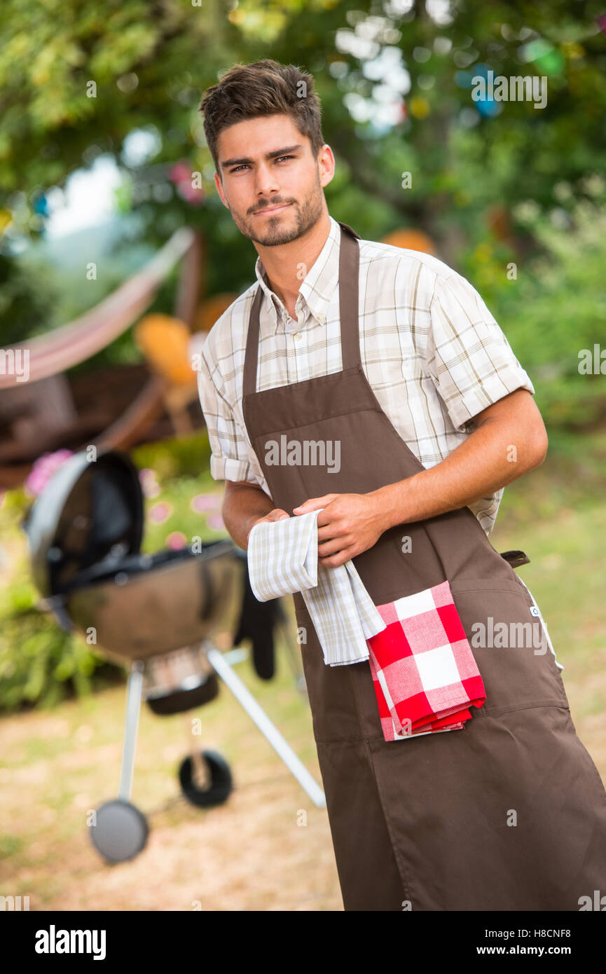 Handsome man preparing barbecue for friends, France Stock Photo - Alamy