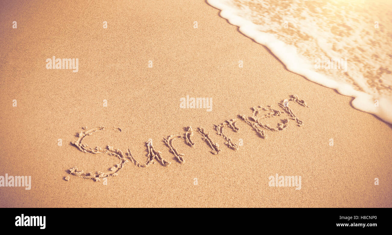 Summer written on sand with surf Stock Photo - Alamy