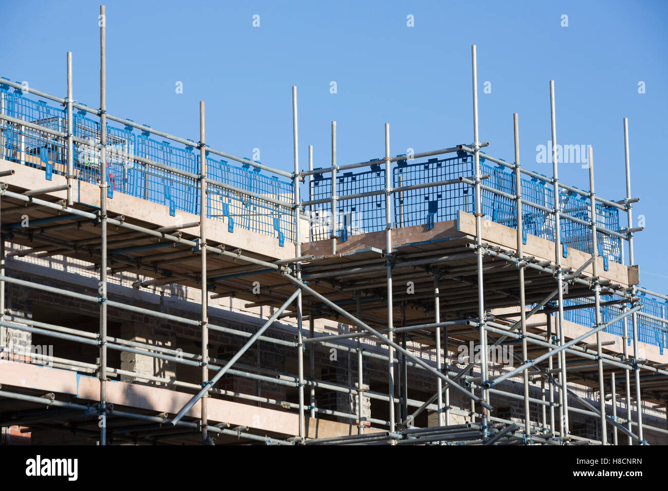 A large new building on a construction site covered in scaffolding in ...