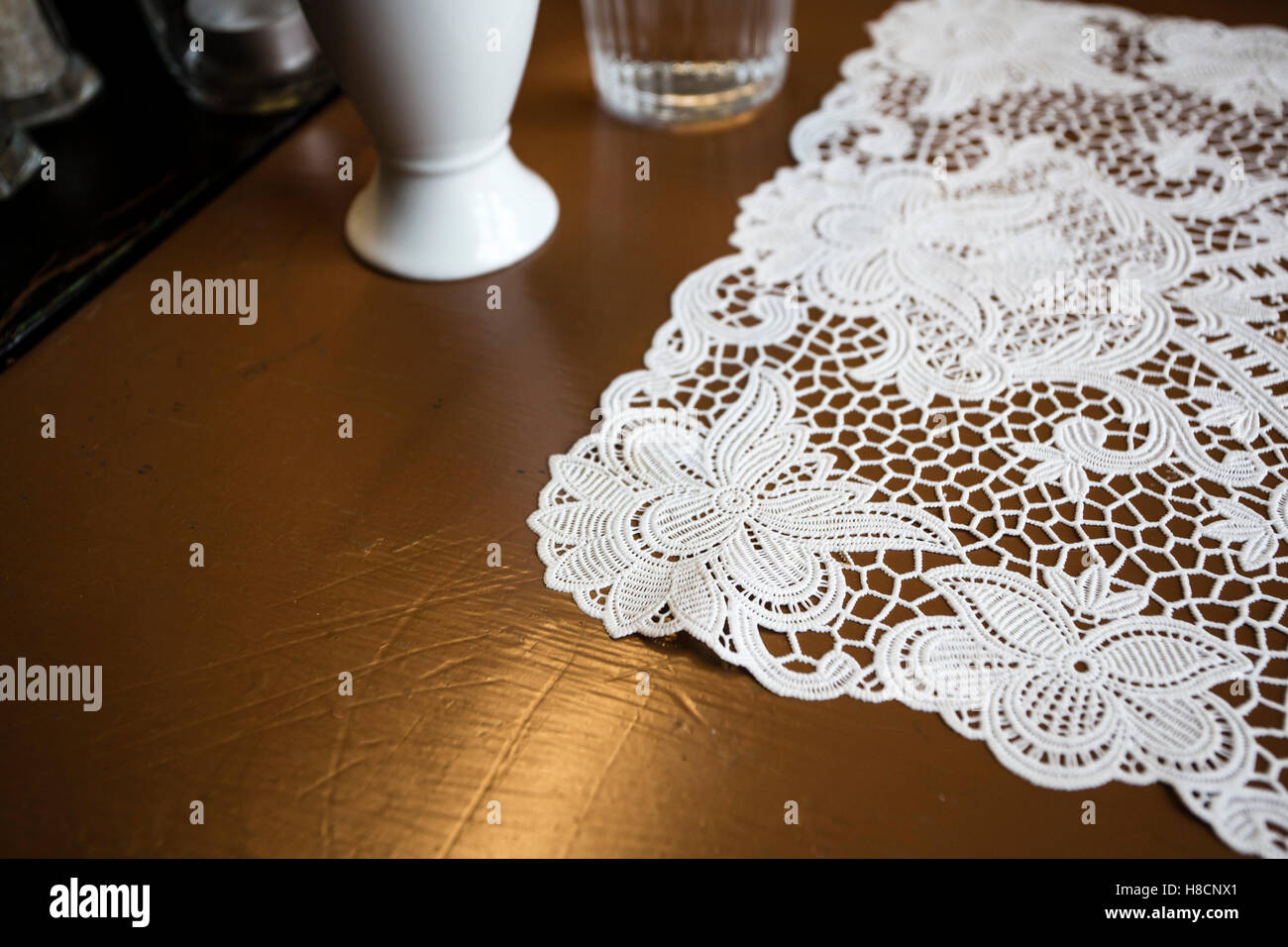 Lace paper doyle on an old worn wooden table in a small restaurant ...