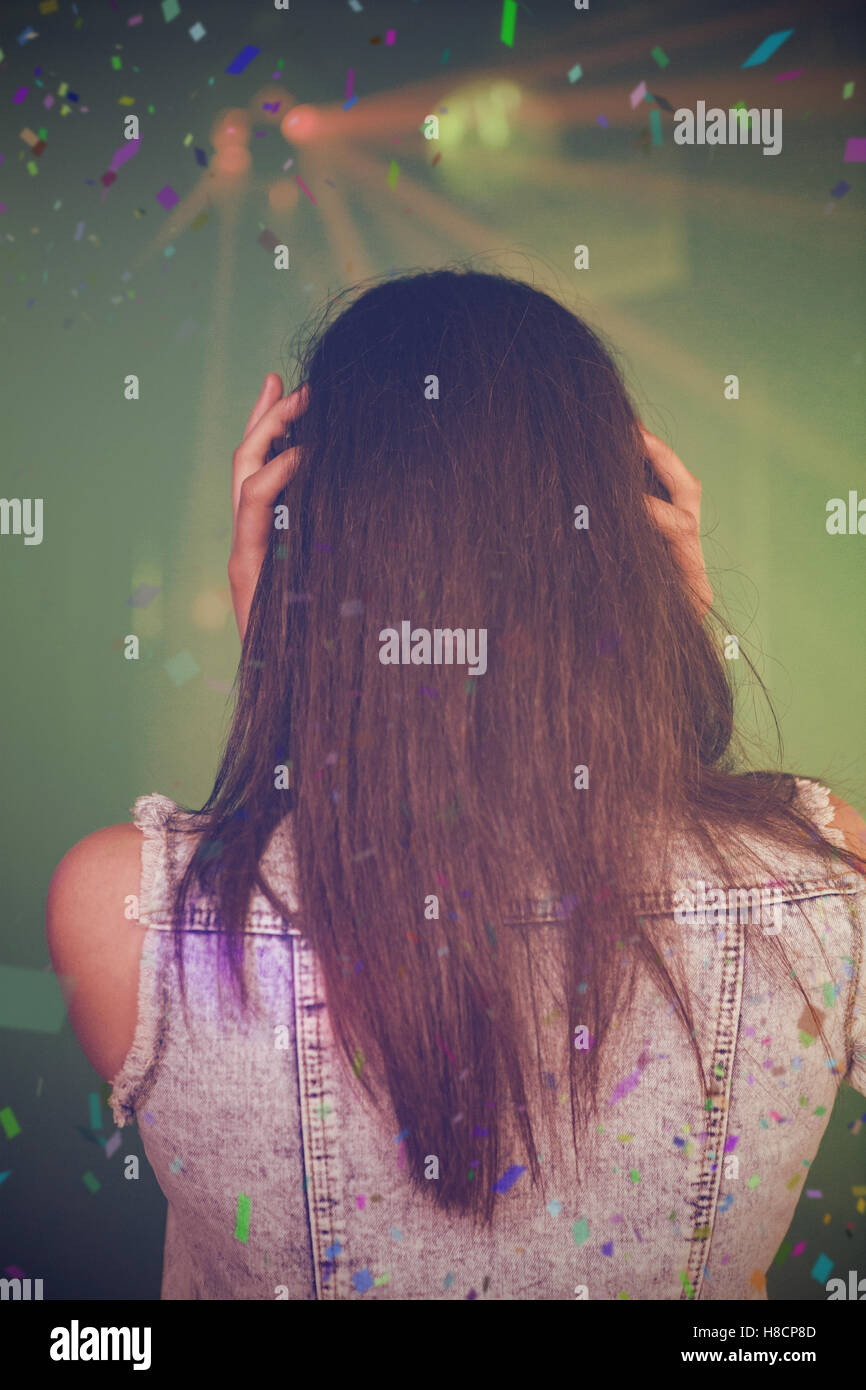 Composite image of rear view of female dj listening music on headphone ...