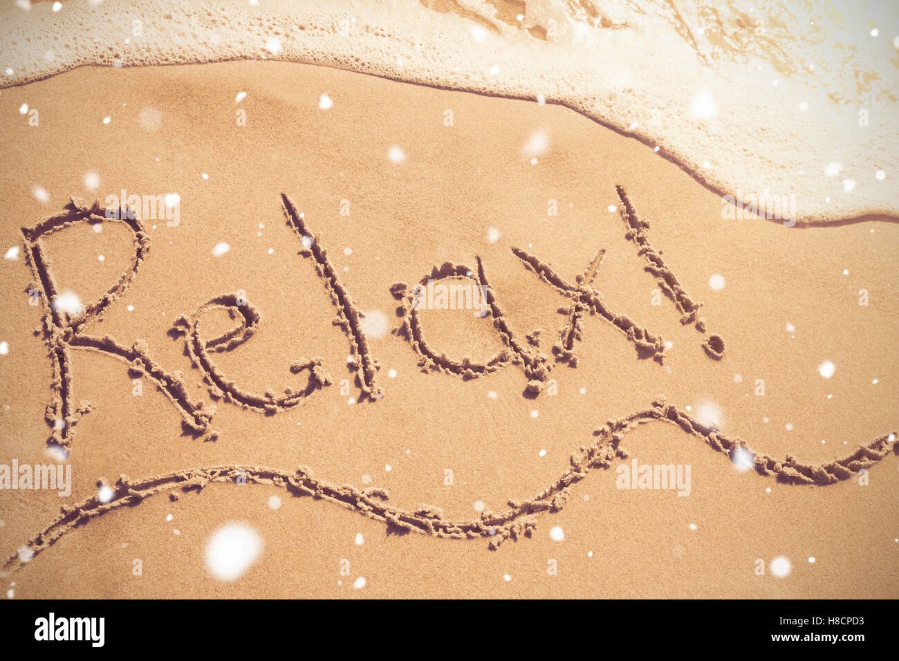 Relax written on sand Stock Photo - Alamy