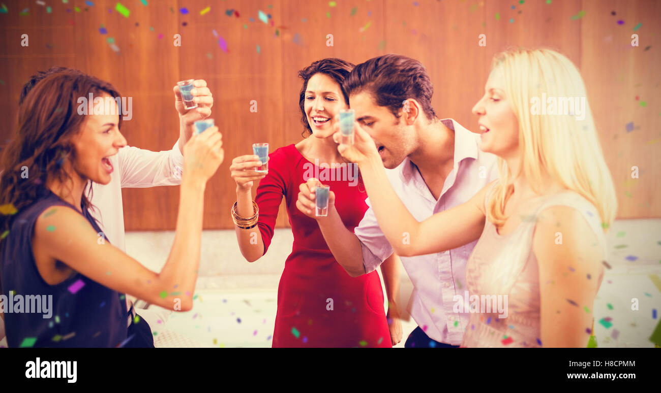 Composite image of friends toasting shots while standing together Stock ...