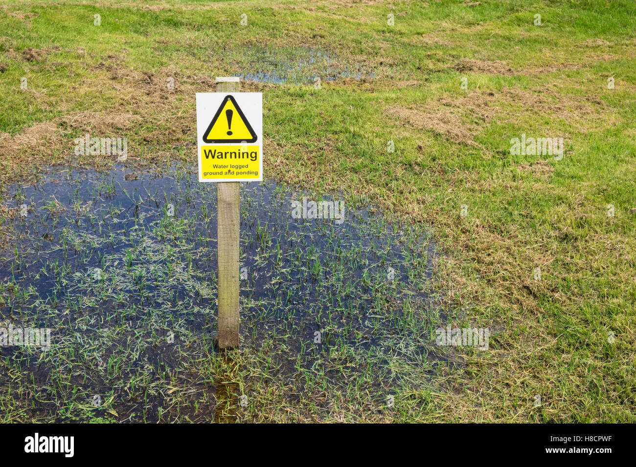 Warning sign, water logged ground Stock Photo - Alamy